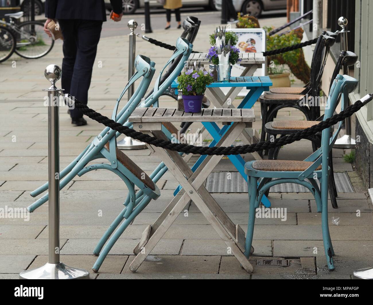 Cafe Tables With Chairs leaning against them Stock Photo - Alamy