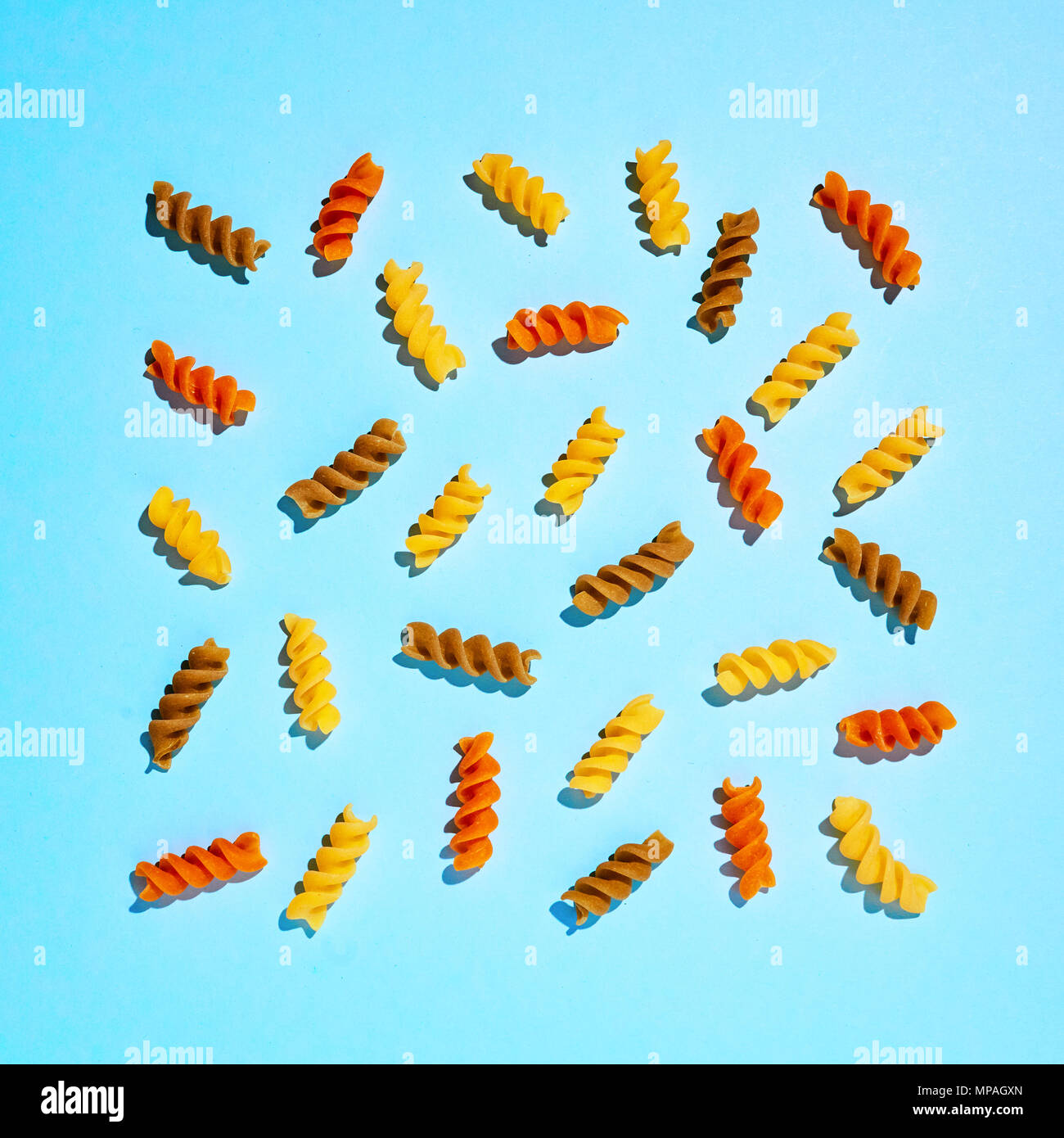 Pattern of multi-colored pasta on a blue background. Flat lay Stock ...
