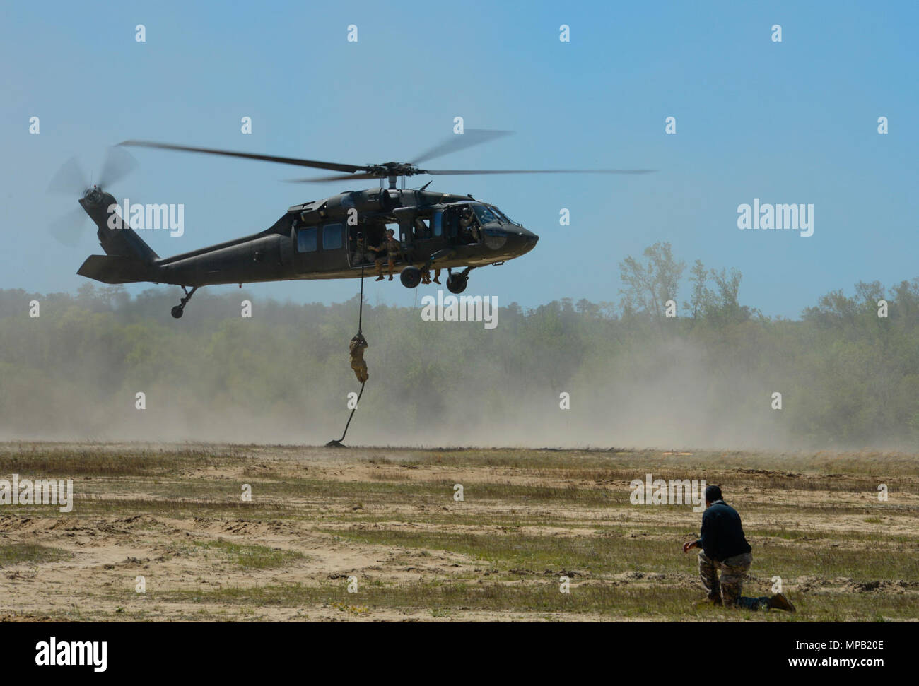 A U.S. Army Ranger fast ropes out of a UH-60 Black Hawk helicopter ...