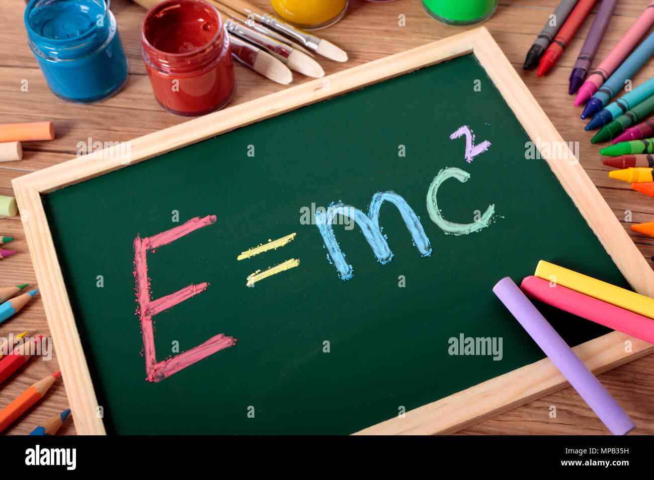 Einstein's famous E=MC2 formula written in color chalk on a small ...