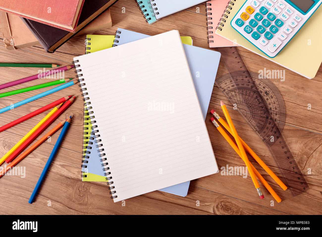 Student's desk with open notebook, text books, various pencils and ...