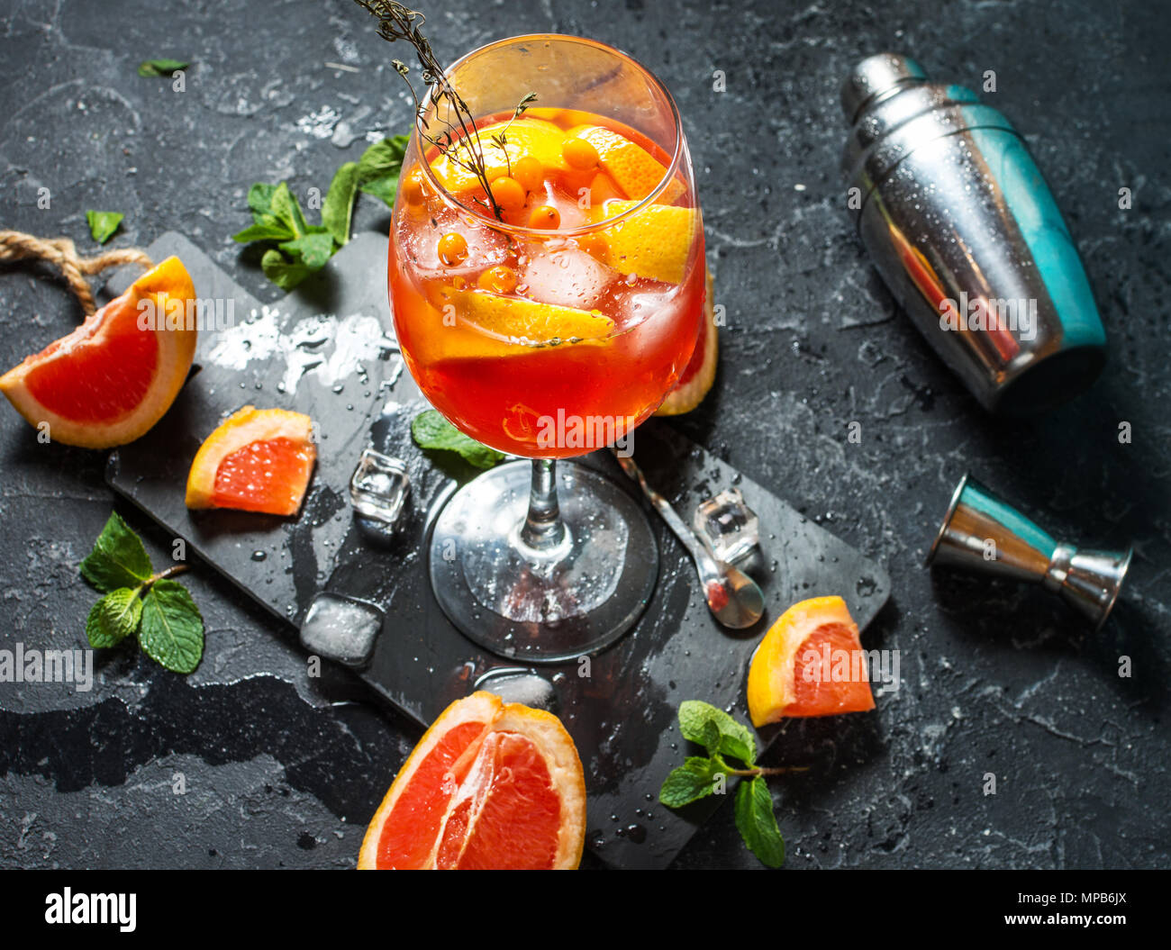 Cocktail drink on stone board. Alcoholic beverage with grapefruit and ...