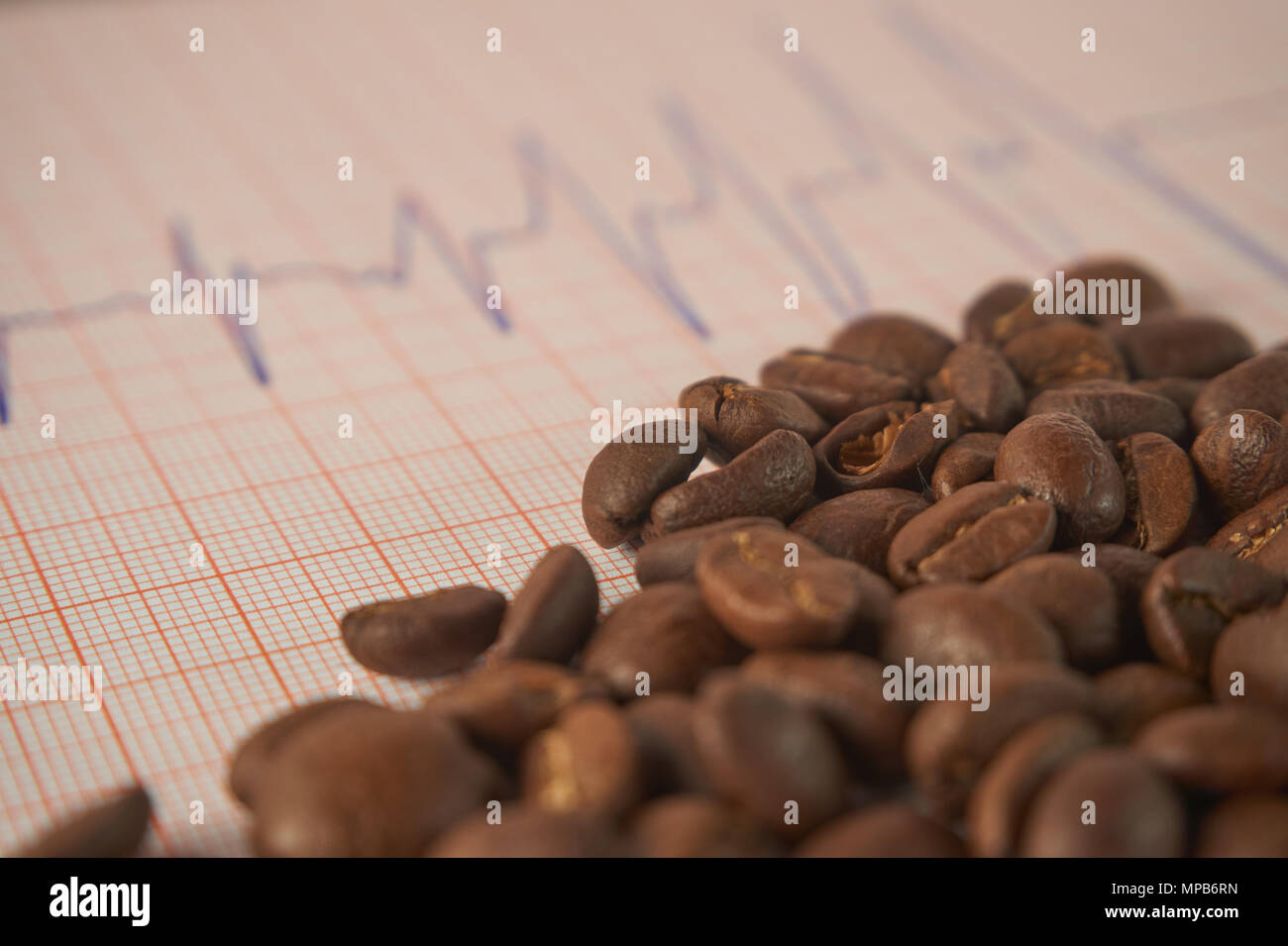 Loose roasted coffee beans on an ECG tracing showing an increased heart ...
