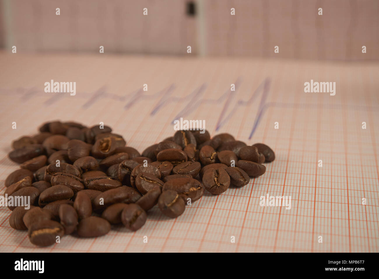 Loose roasted coffee beans on an ECG tracing showing an increased heart ...