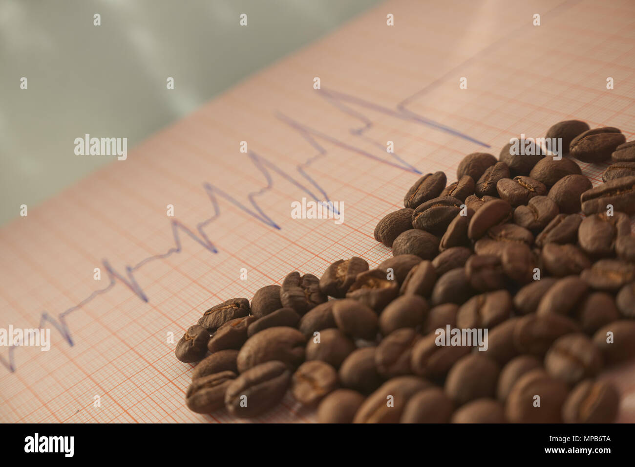 Loose roasted coffee beans on an ECG tracing showing an increased heart ...