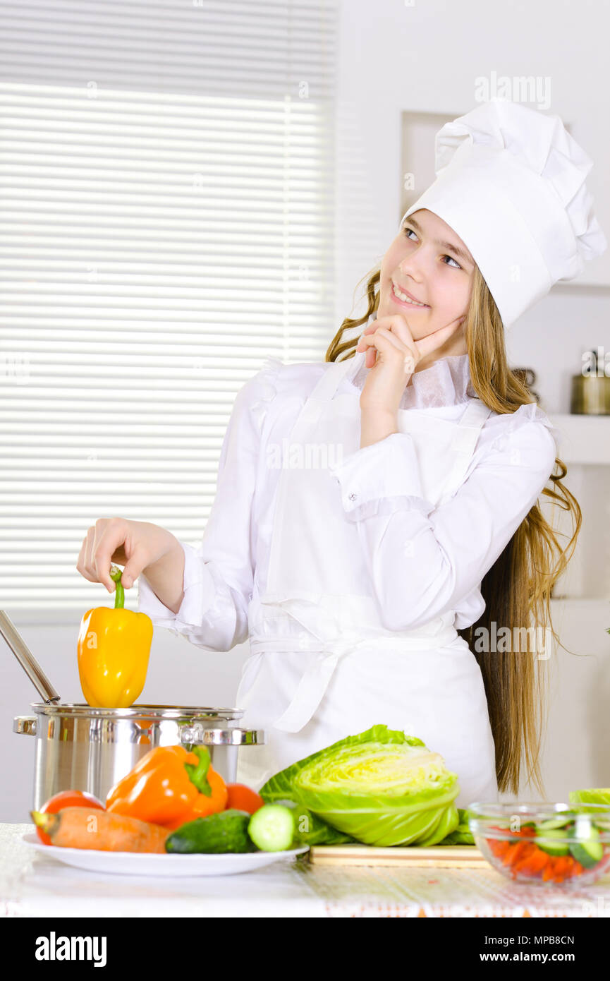 Portrait of girl wearing chef uniform cooking on kitchen Stock Photo ...