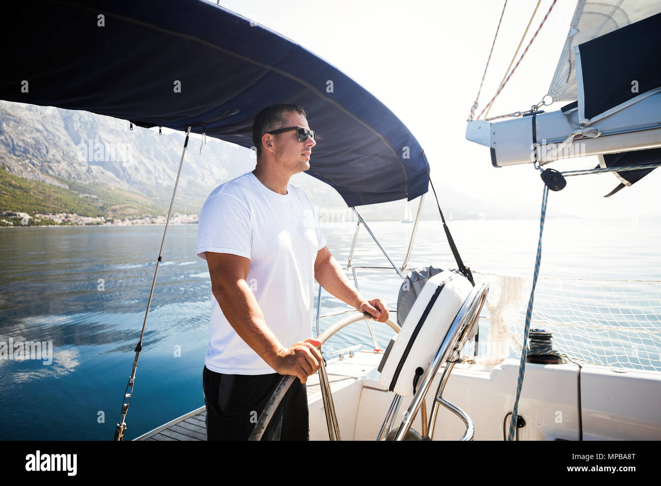 Happy smiling man sailing with his yacht Stock Photo - Alamy