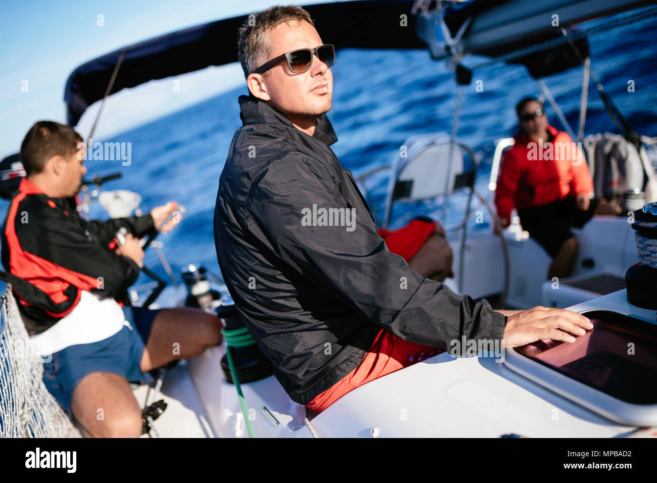 Handsome strong man sailing with his friends Stock Photo - Alamy