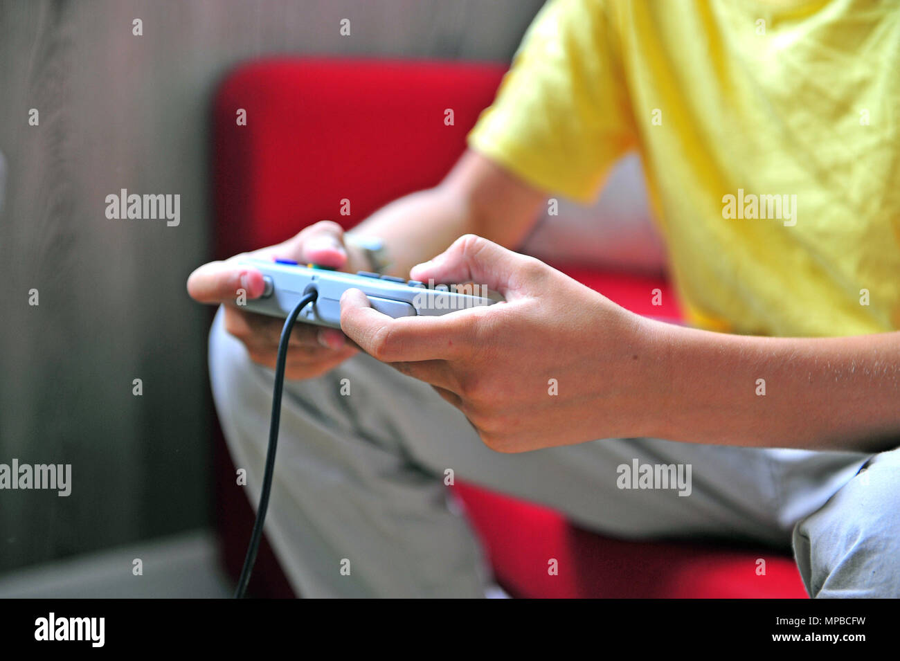 Children's hands holding game console controller Stock Photo - Alamy