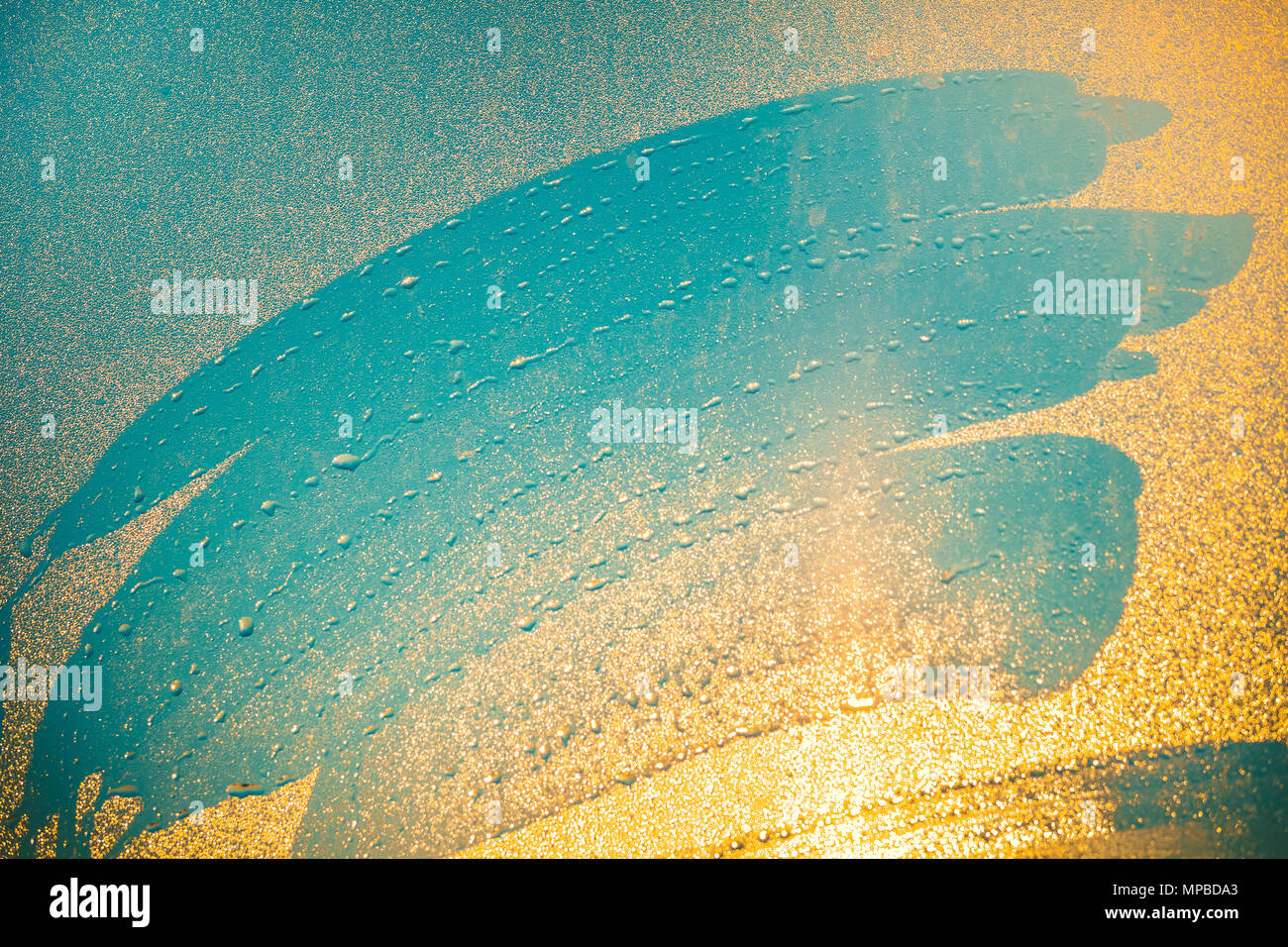 Close-up imprints of the fingers on the water dust sprayed window. Blue ...