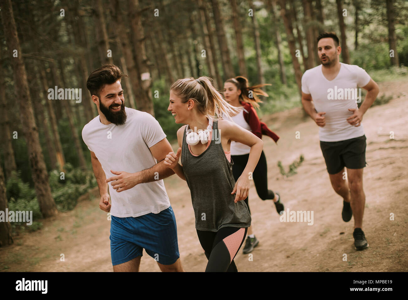 Group of young people run a marathon through the forest Stock Photo - Alamy