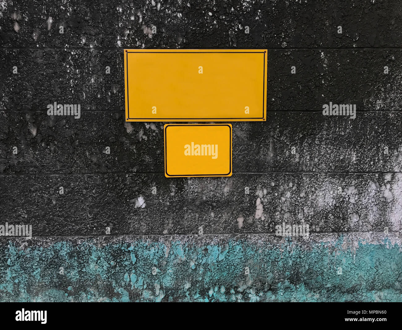 blank empty yellow notice board on mossy aged grunge rough stone wall ...