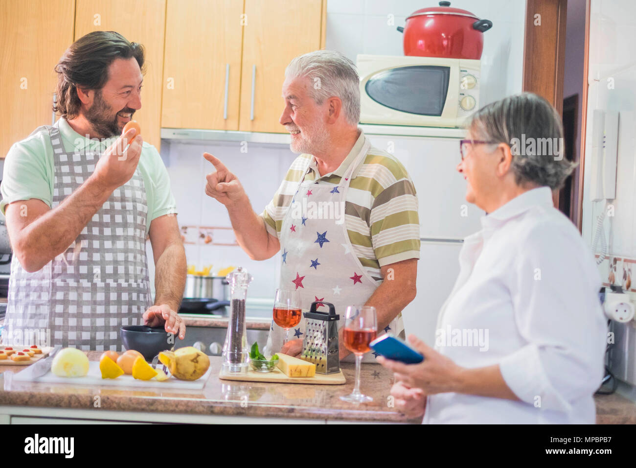 Indoor kitchen scene tiwh a family cooking. Father, mother and son ...