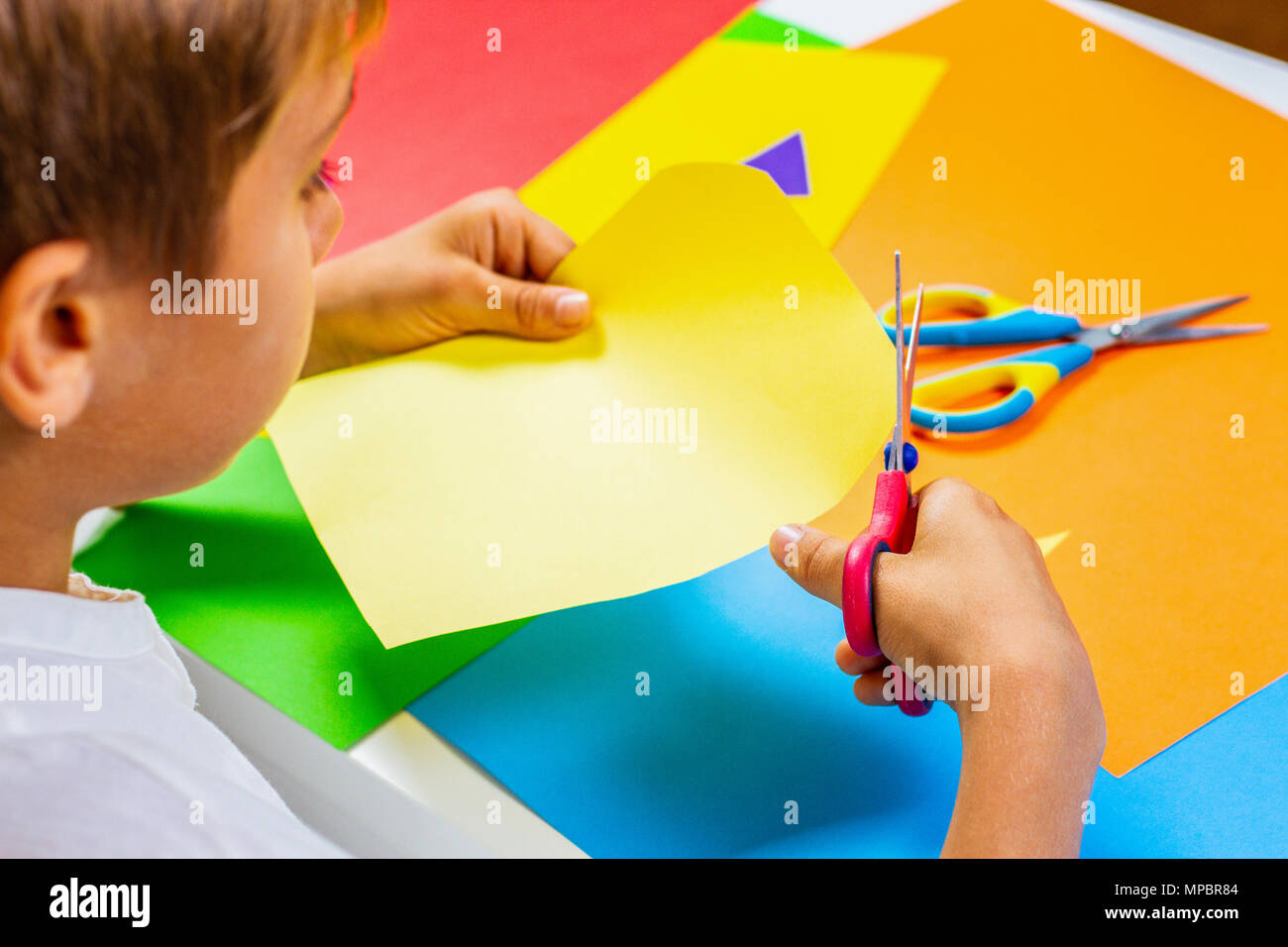 Elementary boy cutting paper scissors hi-res stock photography and ...