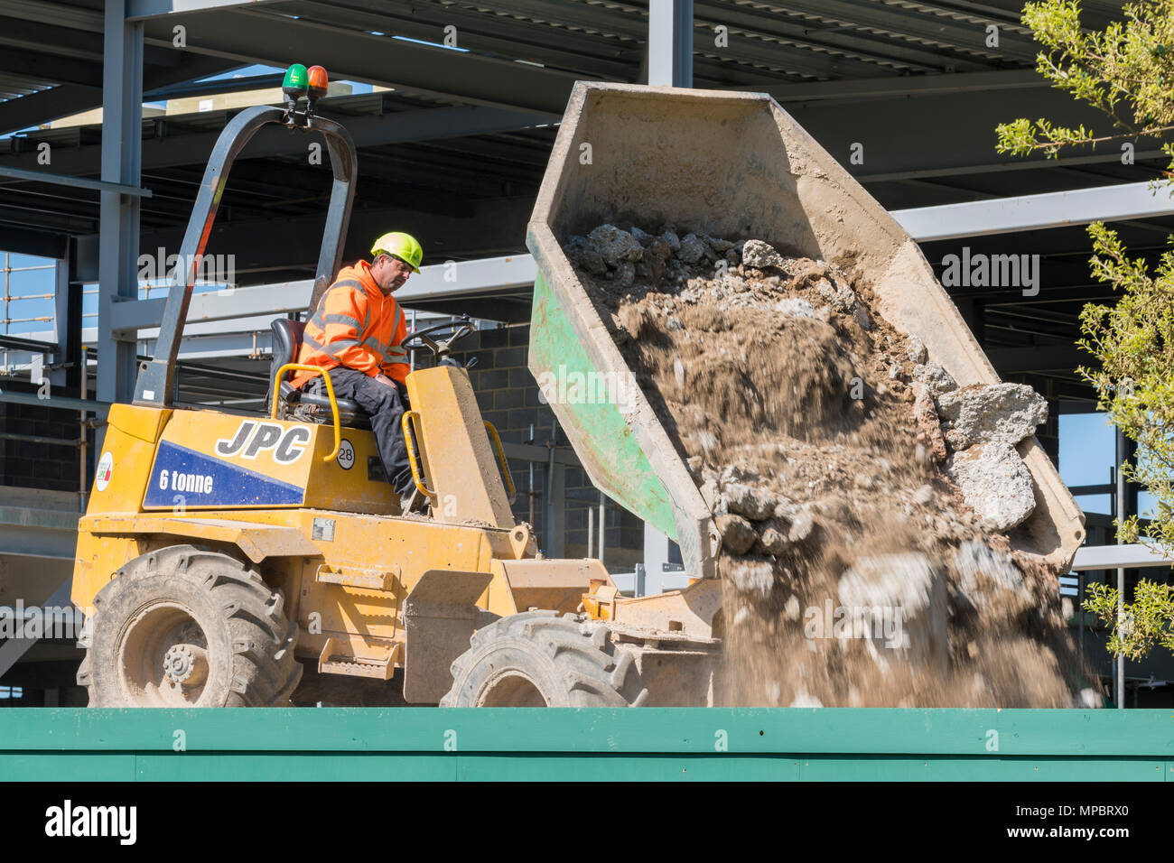Construction vehicle on a building site tipping out rubble. JPC vehicle ...