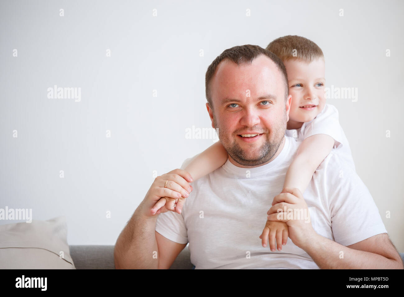 Image of young father with his son on empty background Stock Photo - Alamy