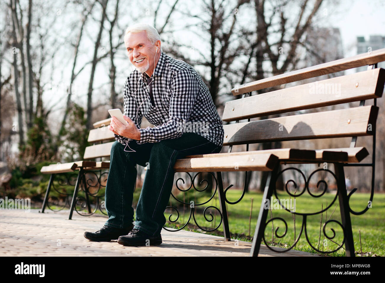 Positive senior man listening to audio Stock Photo - Alamy