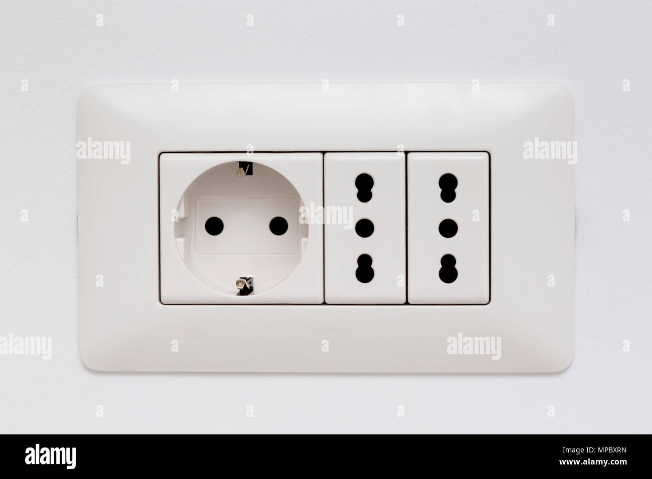 Modular socket composed by three power outlet on the white wall Stock ...