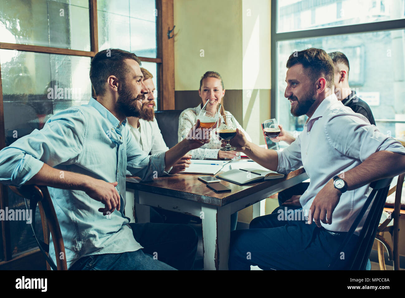 Team job while relaxing in pub Stock Photo - Alamy