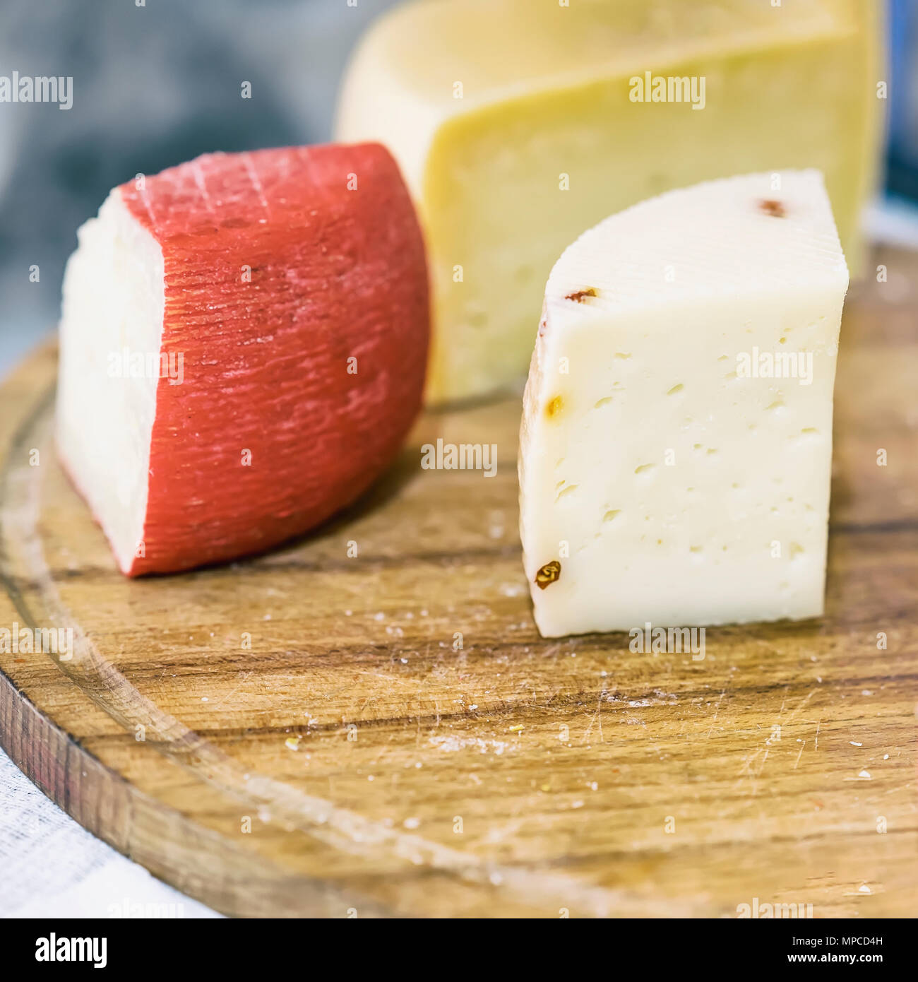Pieces heads of soft cheeses with different additives on wooden market ...