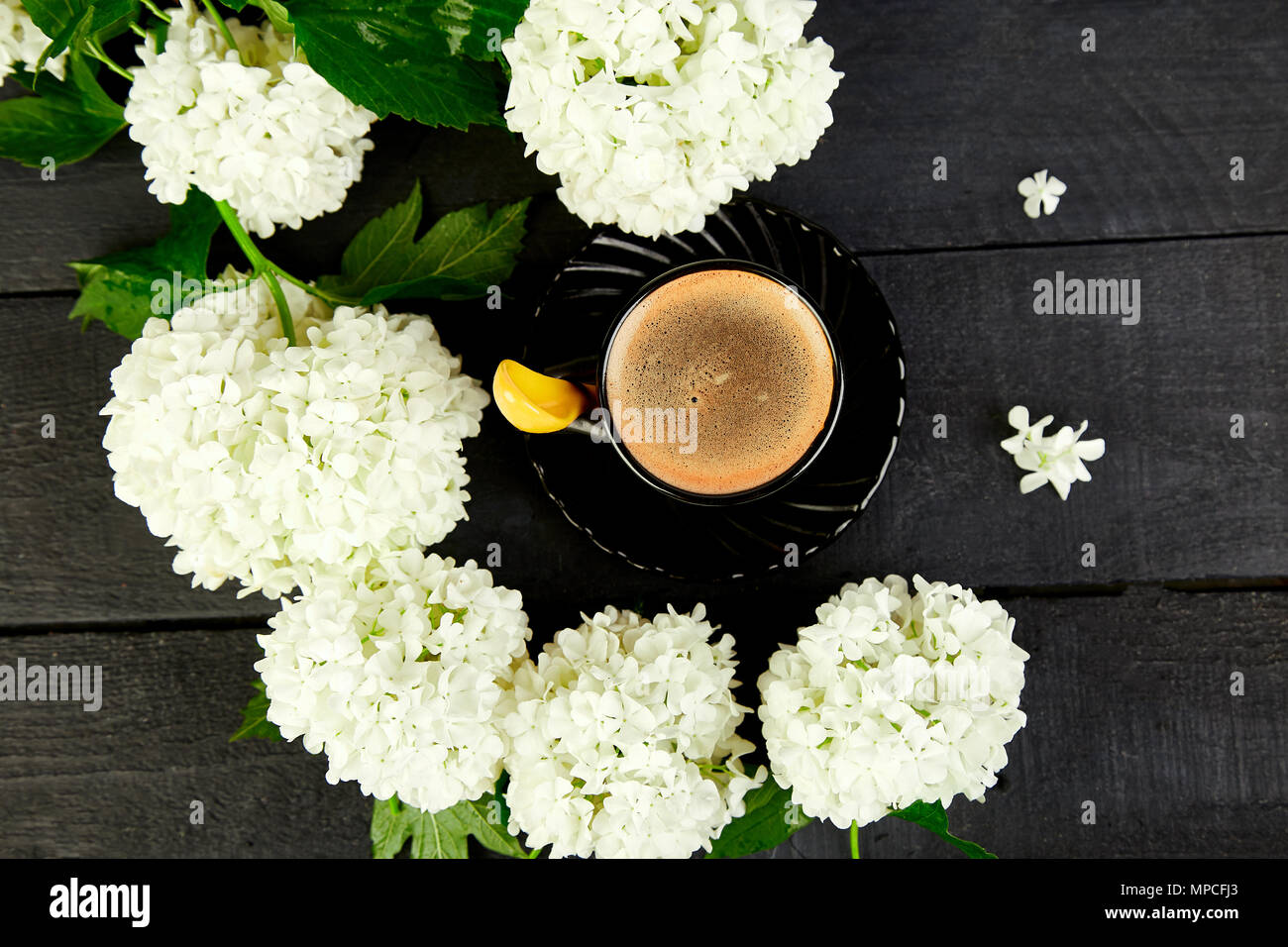 Cup of coffee with bouquet flower hydrangea on black wooden background ...