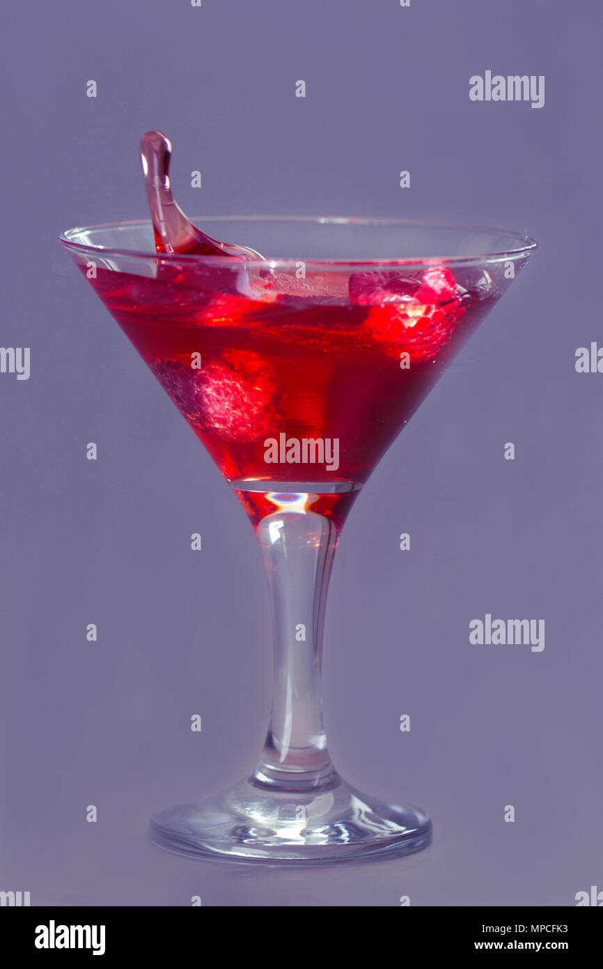 Drop of water falling in martini glass in purple tones Stock Photo - Alamy