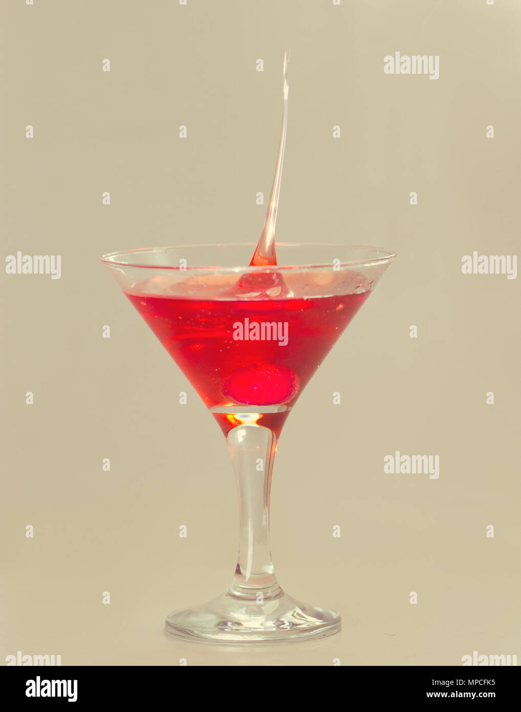 Drop of water falling in martini glass in purple tones Stock Photo - Alamy