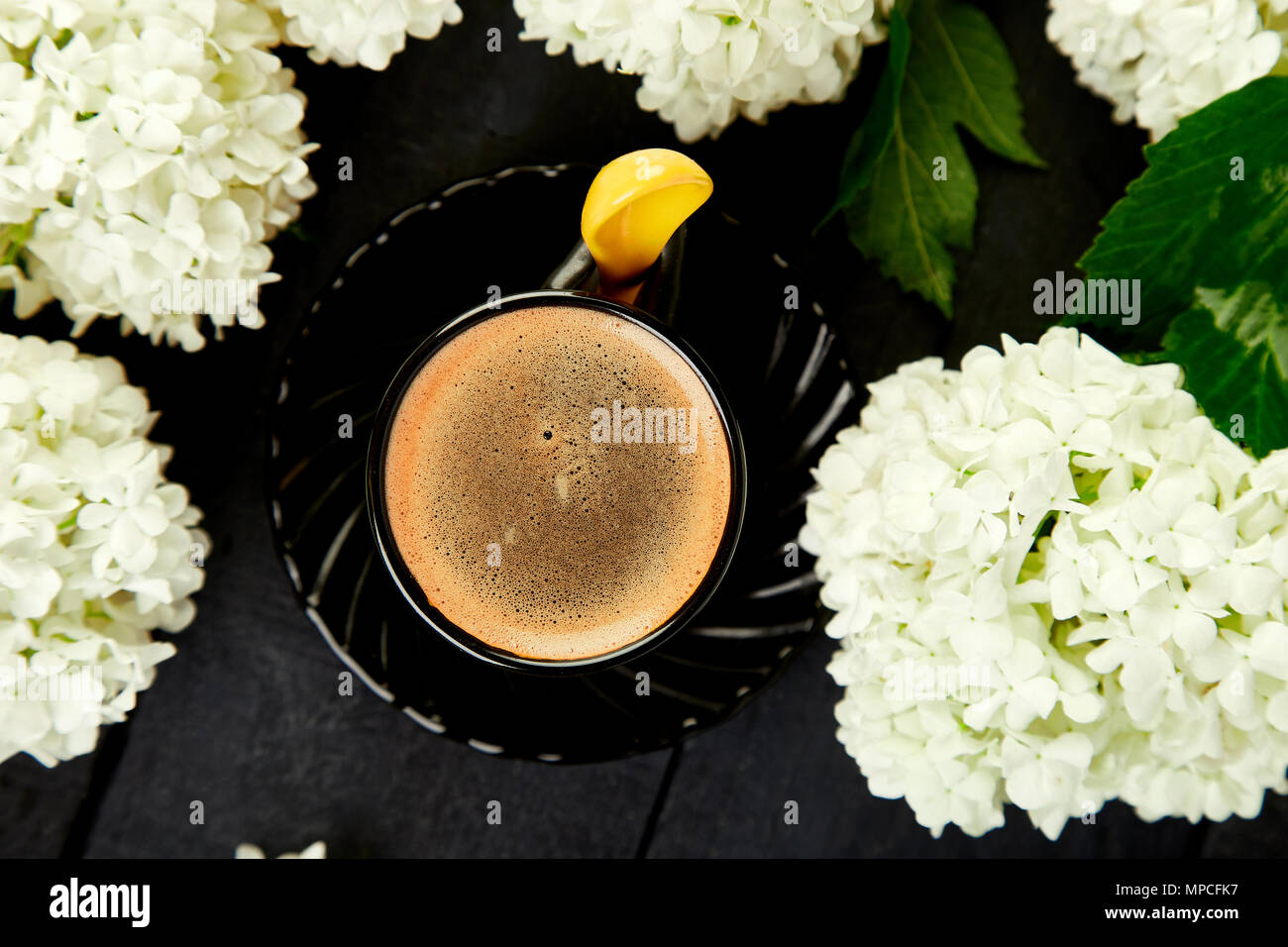Cup of coffee with bouquet flower hydrangea on black wooden background ...