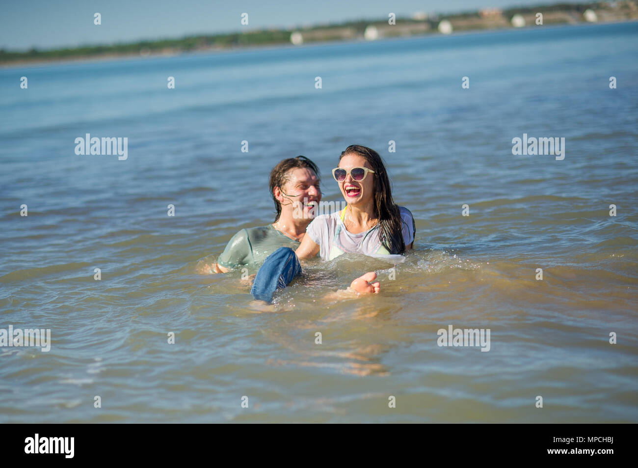 Young couple bathing in the sea. Guy and girl are merrily floundering ...