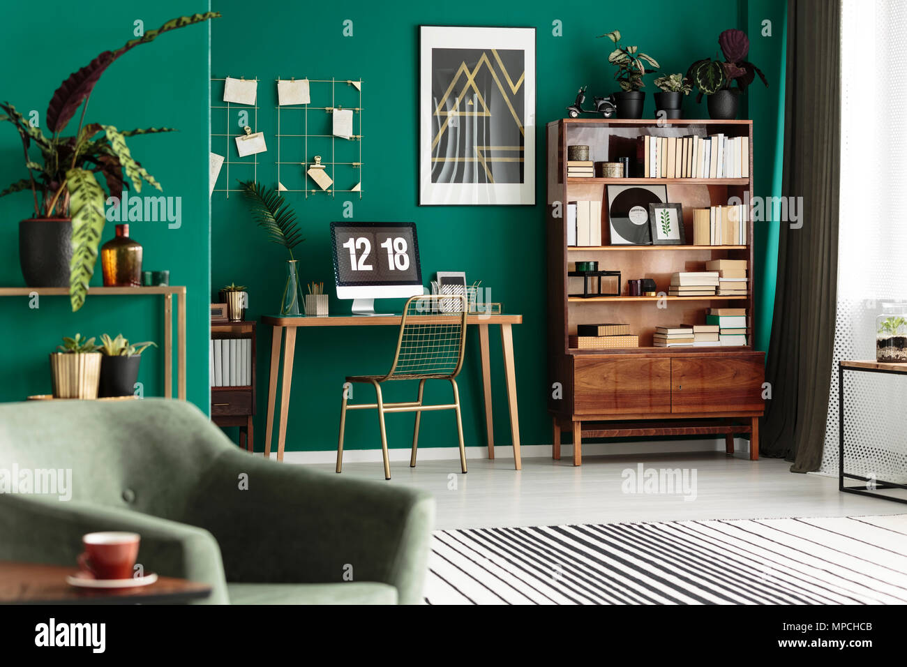 Gold chair at desk with desktop computer in green, cozy apartment ...