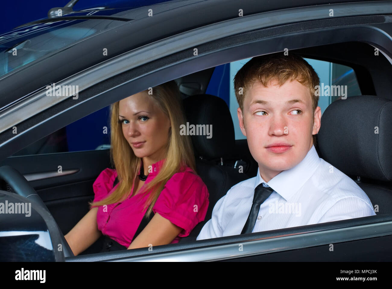 Happy young family sitting in black car looking out windows Stock Photo ...