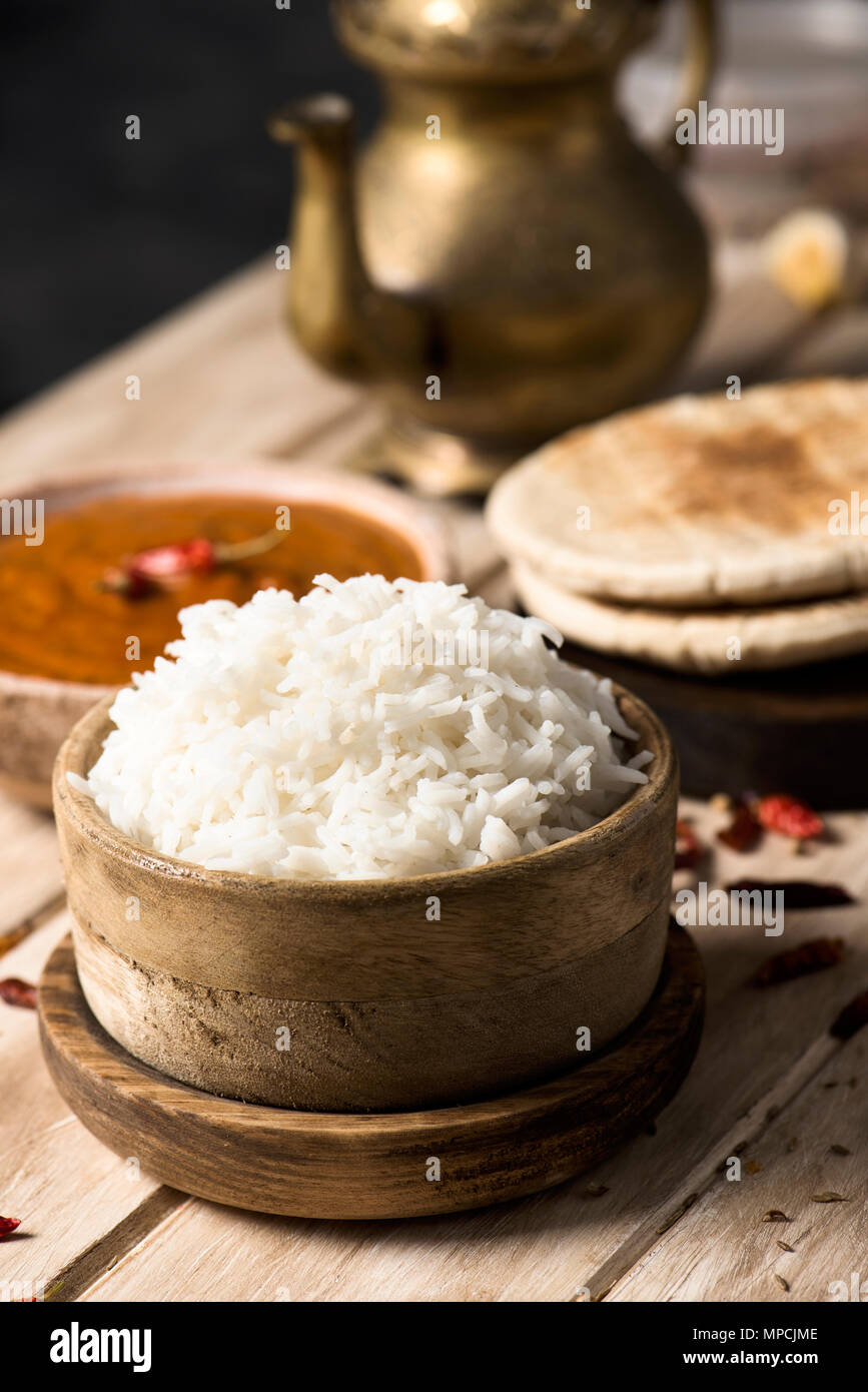 closeup of a bowl with a chicken korma curry, a bowl with cooked rice ...
