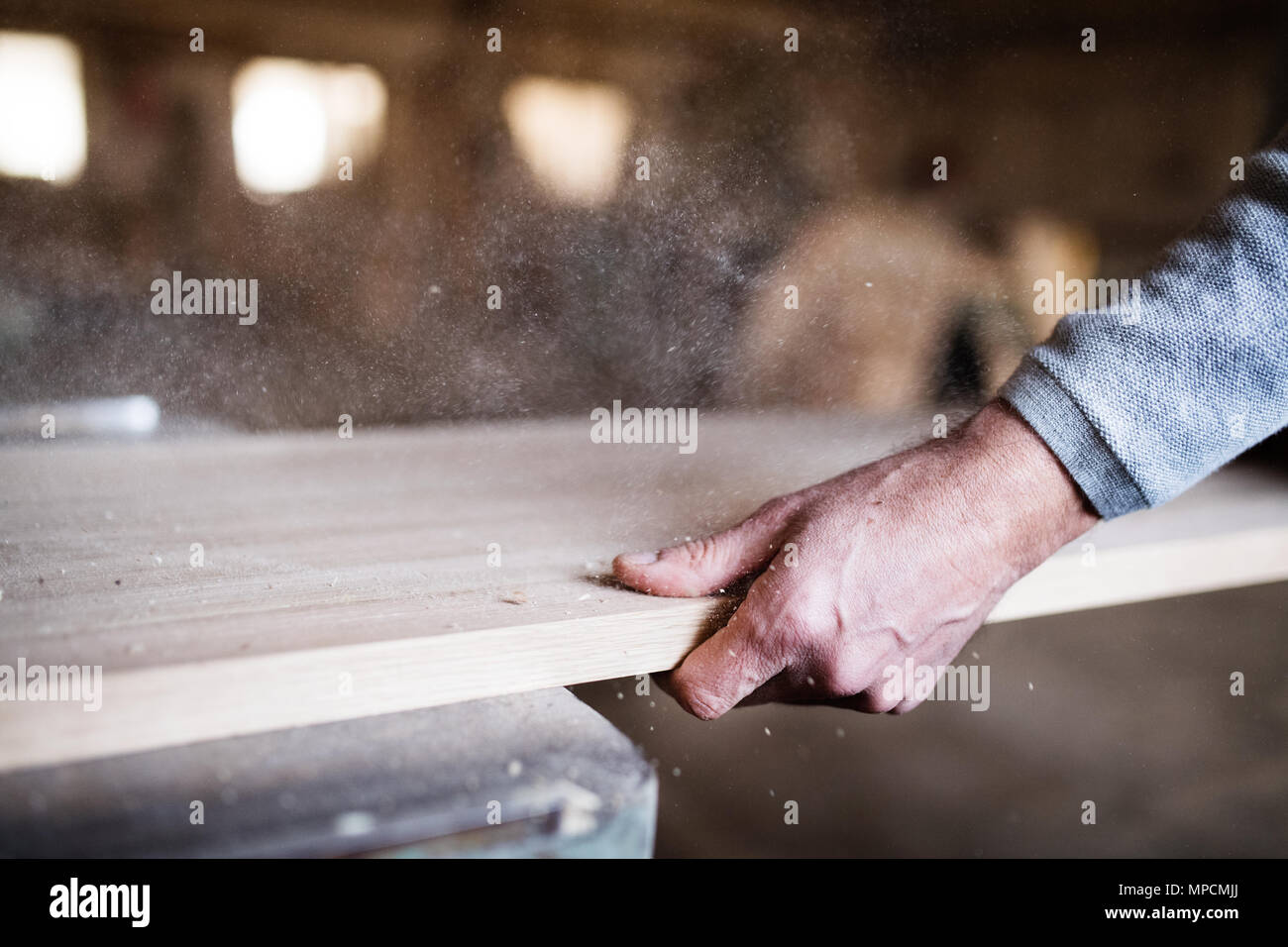 An unrecognizable man worker in the carpentry workshop, working with ...
