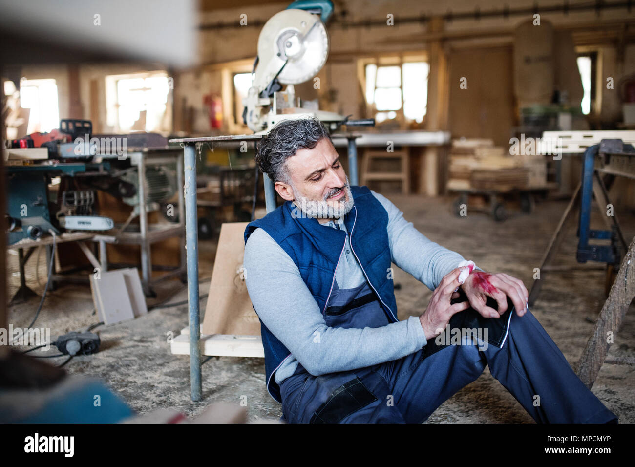 Man with an injured hand after accident at work in the carpentry ...