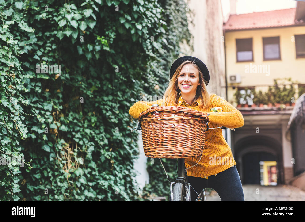 Young woman with bicycle in sunny spring town Stock Photo - Alamy