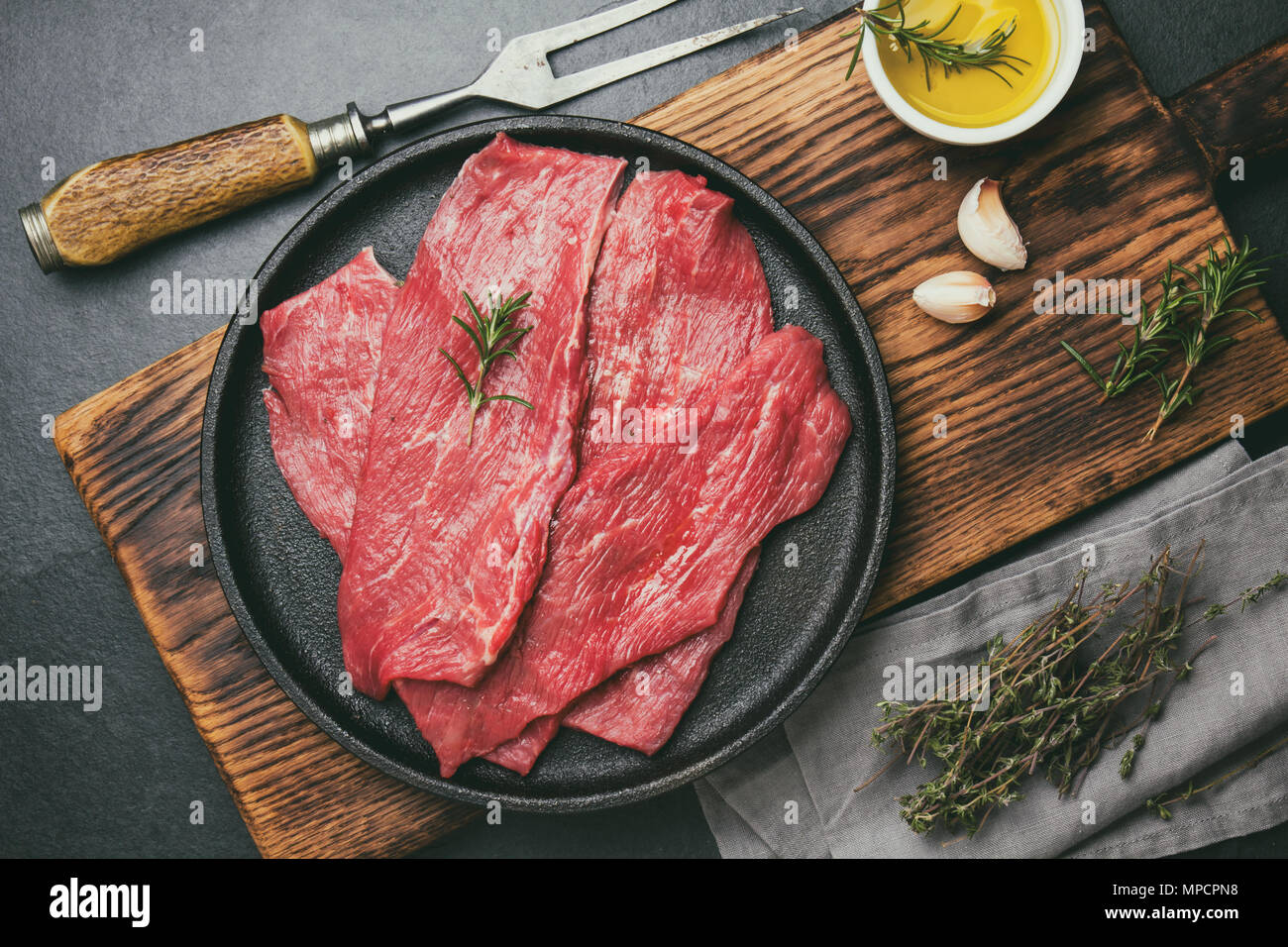 Raw meat beef on cast iron plate. toned, top view Stock Photo - Alamy