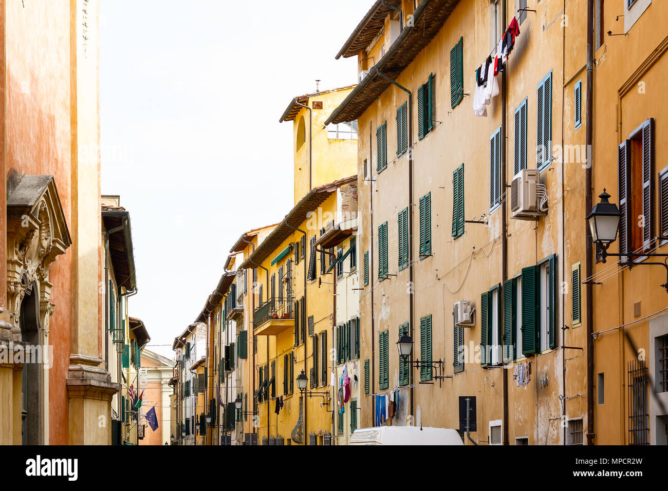 Exterior of traditional Italian buildings with green shutters in Pisa ...