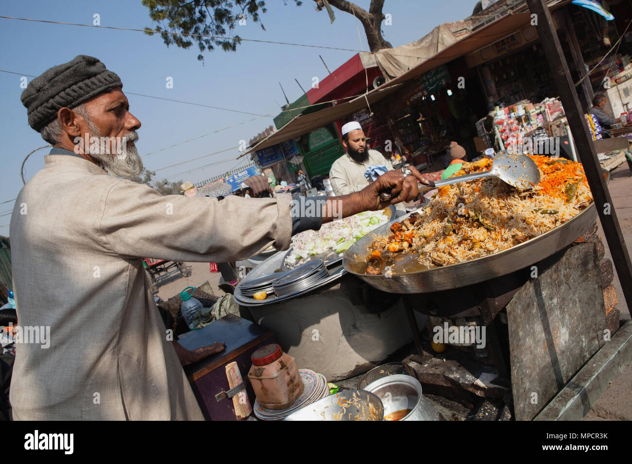 India, New Delhi, A muslim man cooking chicken biryani in the old city ...