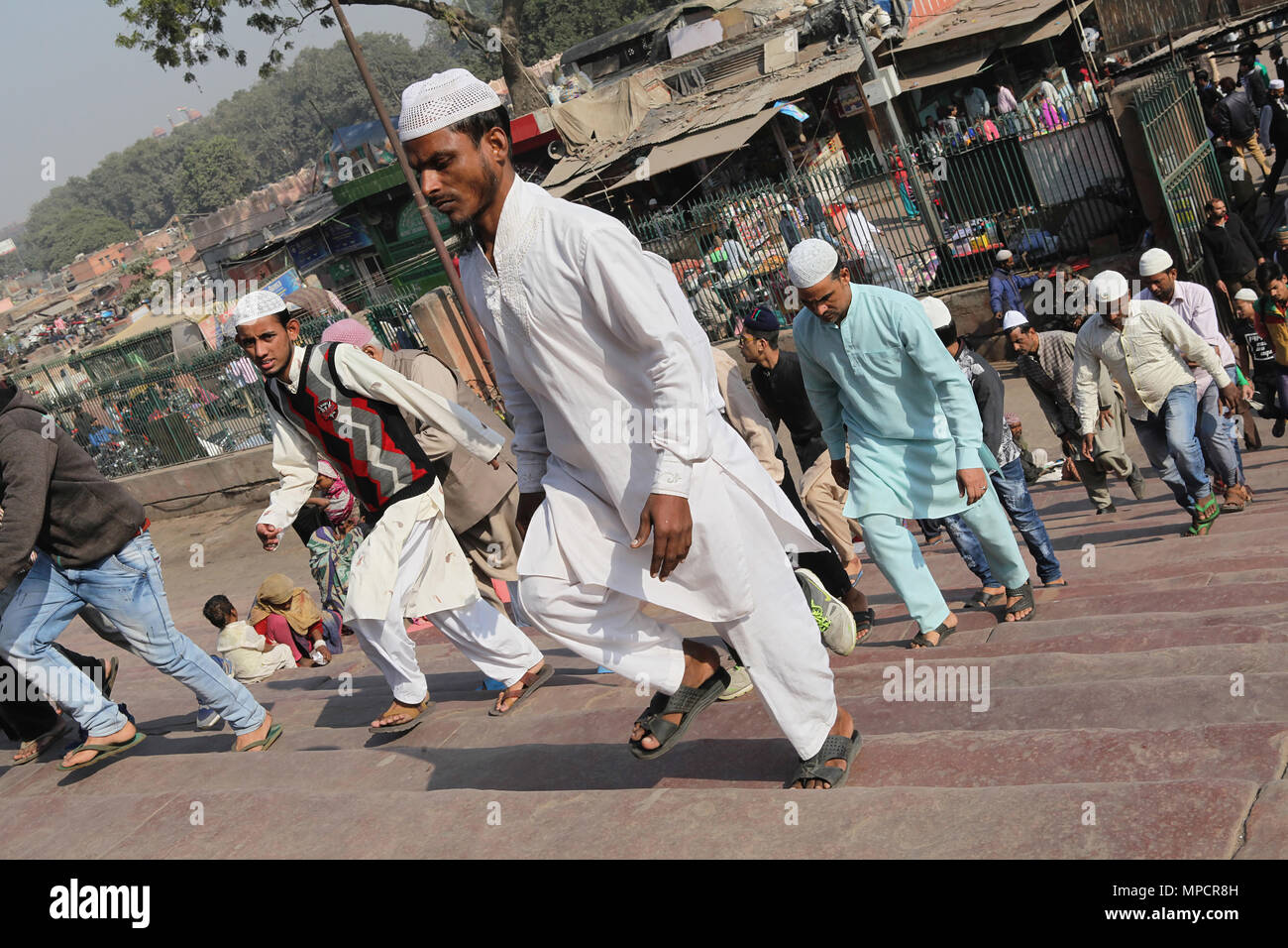 India, New Delhi, Muslim men walking up the steps to the Jama Masjid ...