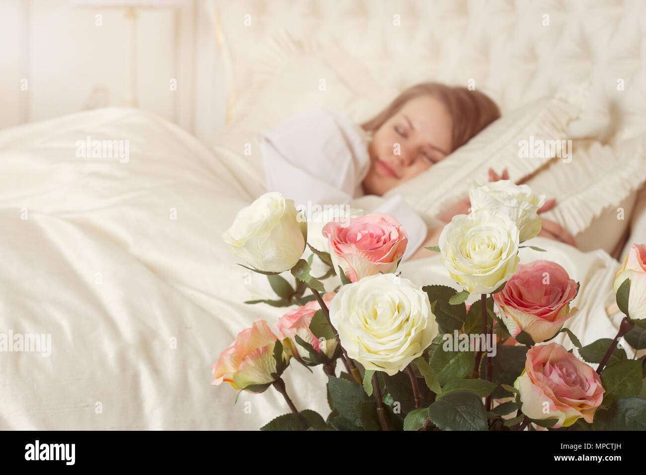 Romance. Beautiful sleeping woman in white bed with red roses Stock ...