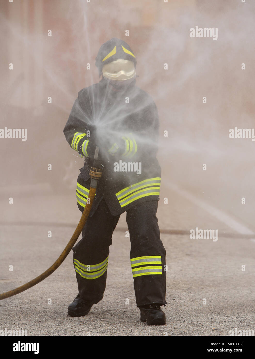 Firefighter uses a fire extinguisher to extinguish a fire during an ...