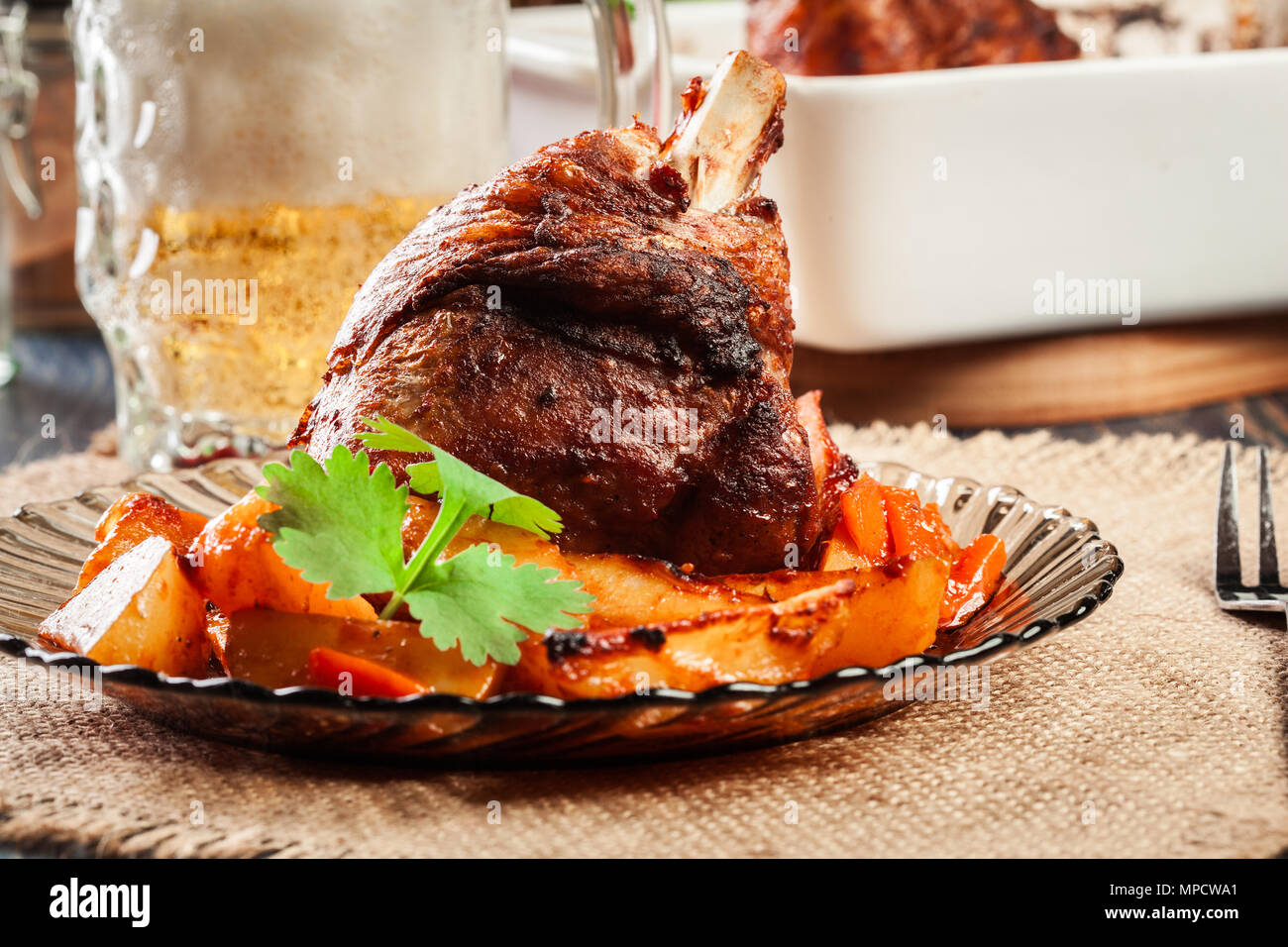 Roasted turkey knuckle with potatoes and vegetable on a plate Stock ...
