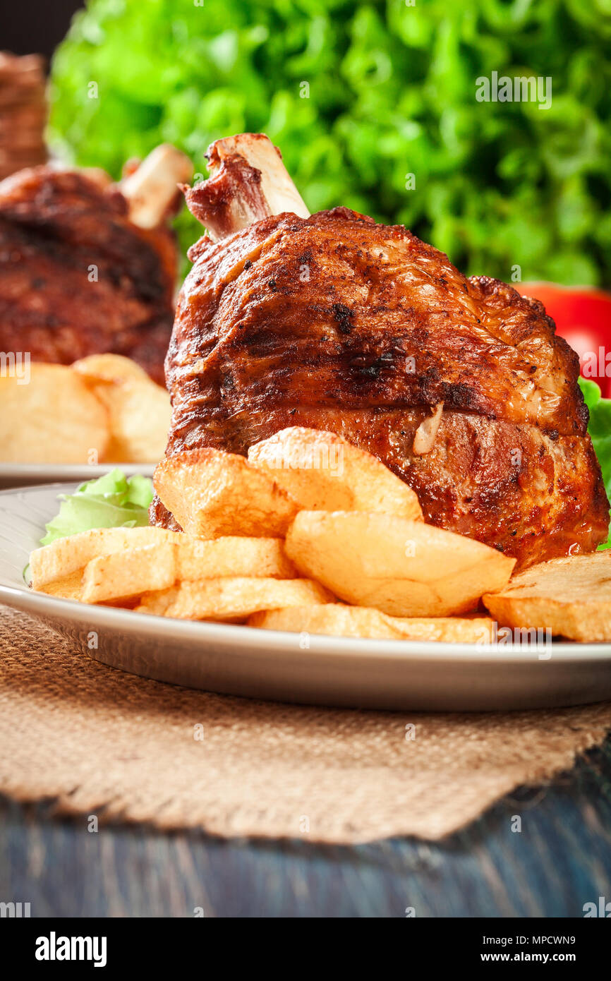 Roasted turkey knuckle with fried potato slices on a plate Stock Photo ...