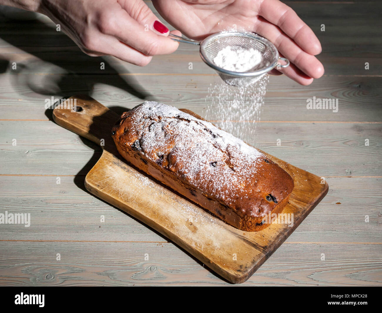 Women's hands sprinkle with powdered sugar home-made blueberry cupcake ...
