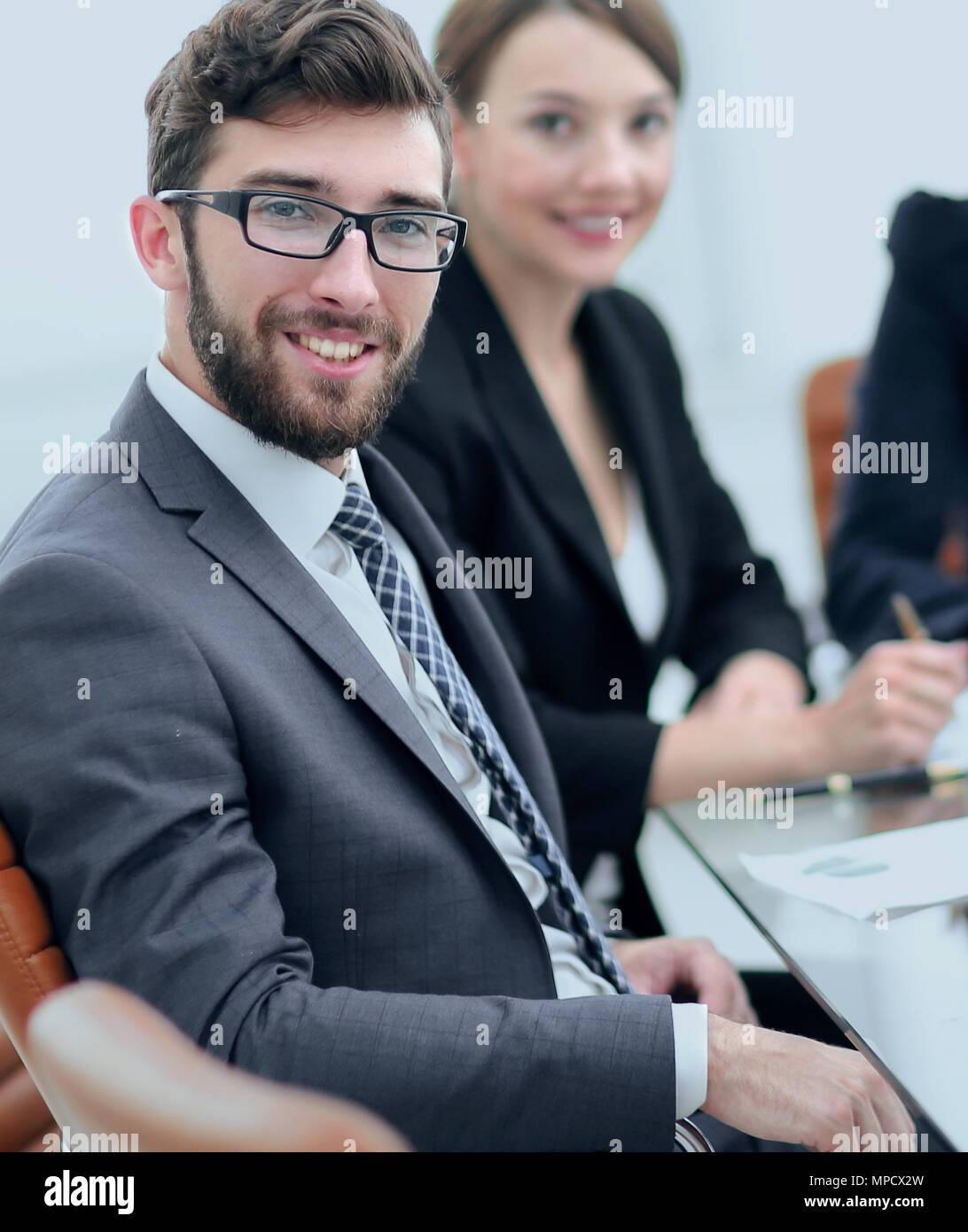 closeup.confident businessman sitting behind a Desk Stock Photo - Alamy