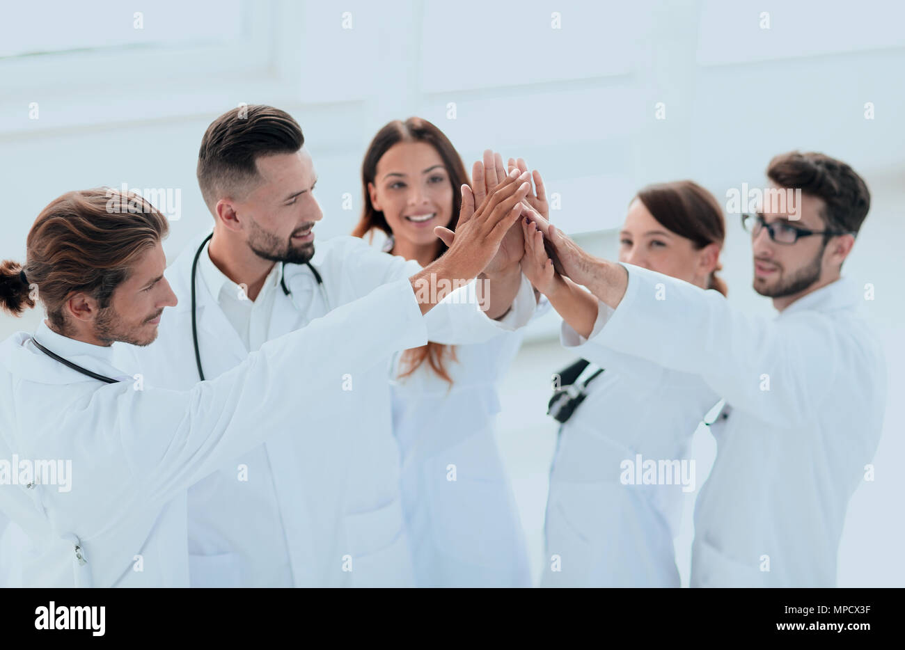 group of doctors giving each other a high five Stock Photo - Alamy