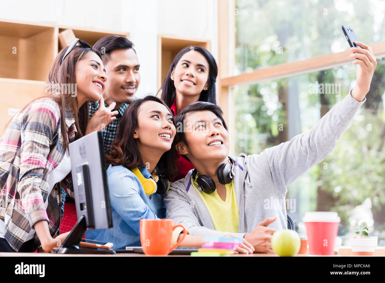 Creative team of five enthusiastic employees making a selfie photo ...