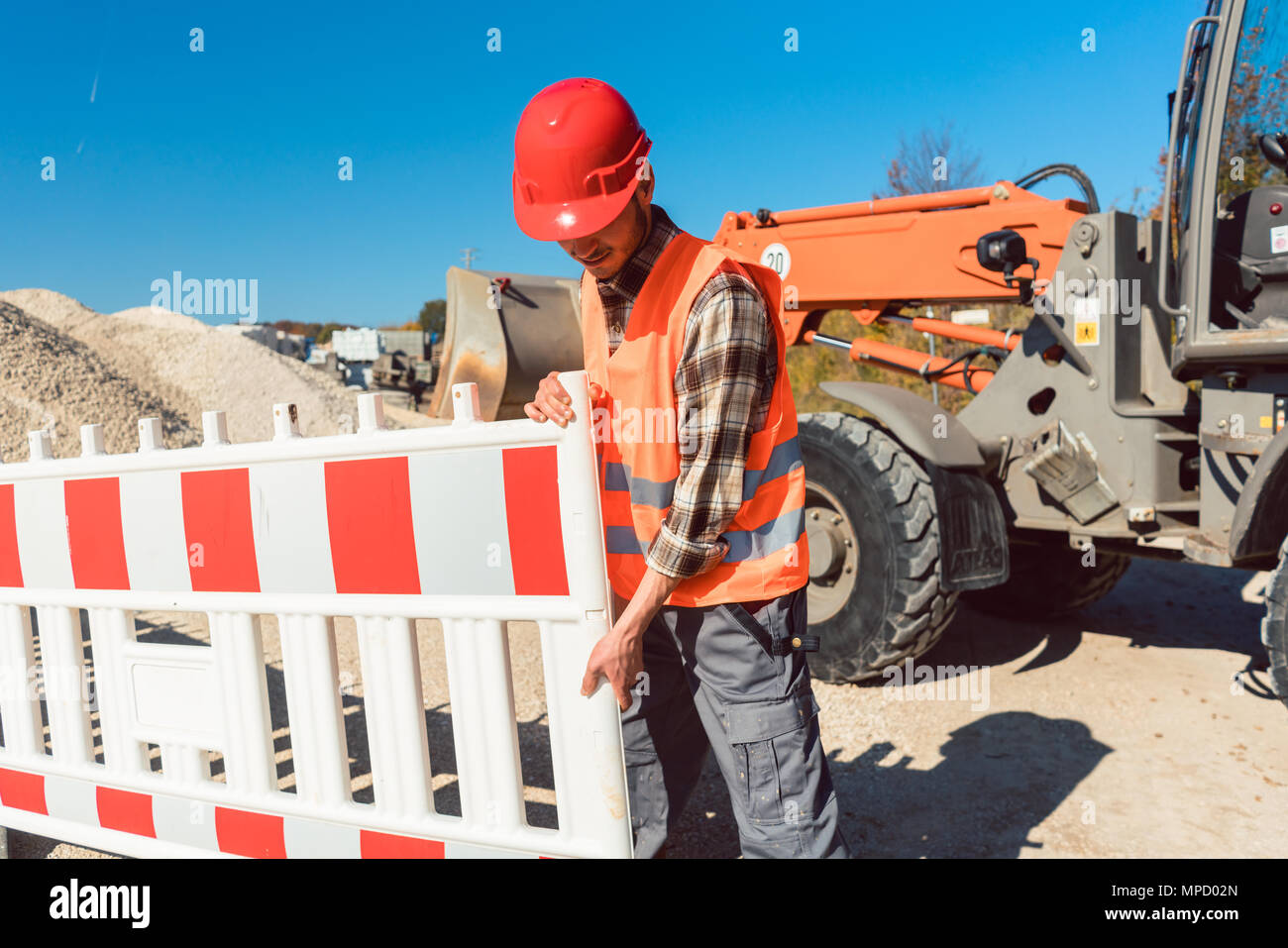 Worker setting up earthworks construction site Stock Photo - Alamy