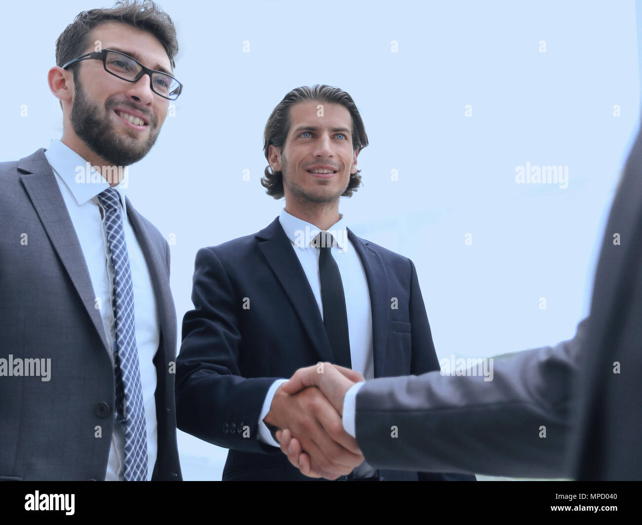 business group welcomes partner with a handshake Stock Photo - Alamy