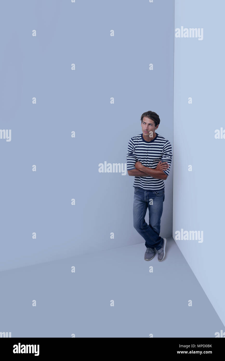 thoughtful man standing in the corner Stock Photo - Alamy